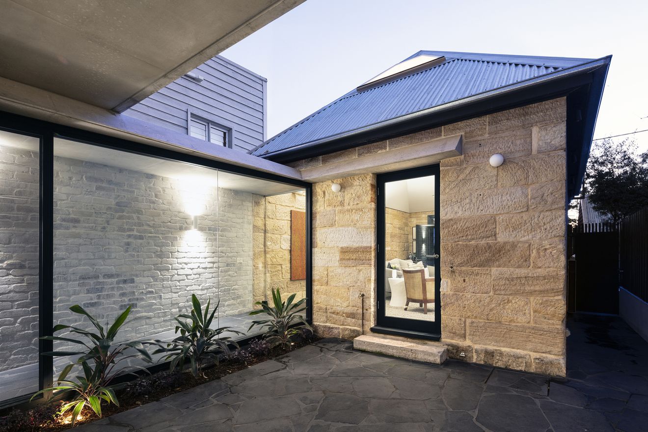 A Dramatic Concrete and Brick Addition to an Old Sandstone Cottage