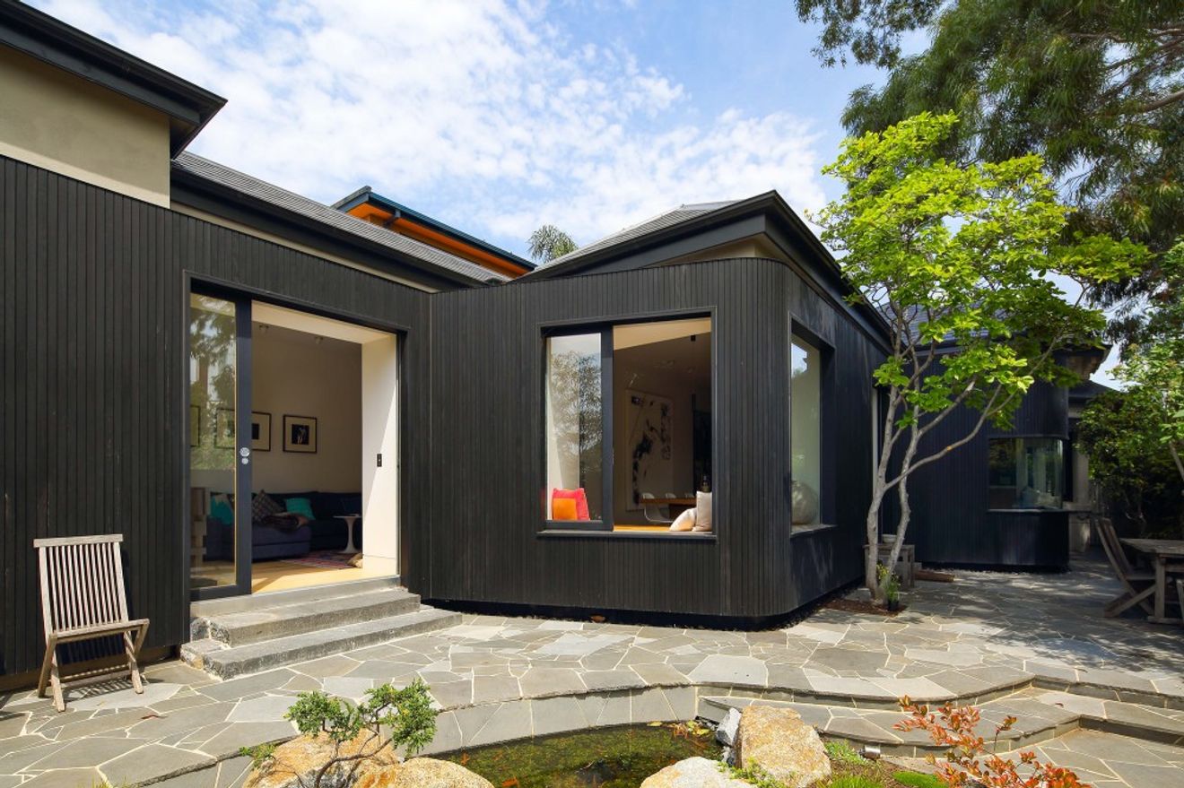 At Merton House a Curving Dark Timber Wall Creates the New Home's Edge